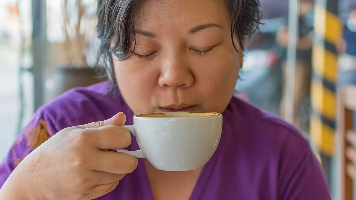 mulher asiática tomando café