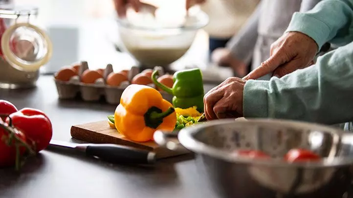 hälsosam livsstil näringsrik mat färska grönsaker frukt ägg matlagning hem mogen äldre familj köksbänk skära paprika