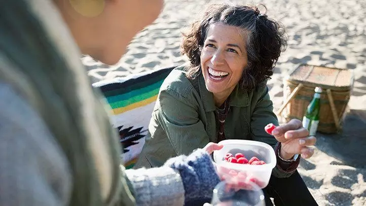 unha muller con depresión comendo comida nunha praia