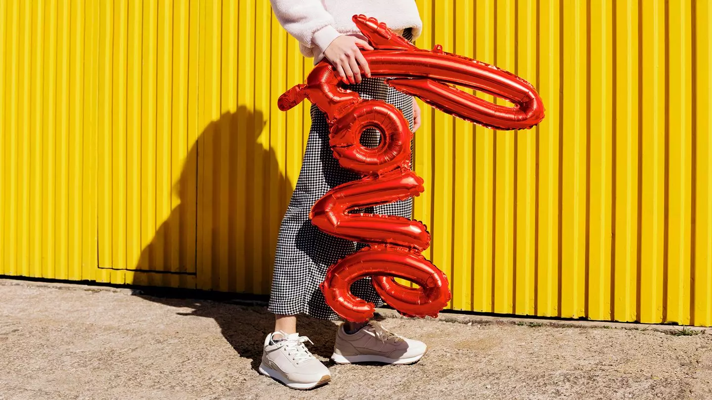 žena drži ljubavni balon na otvorenom urbanoj ulici