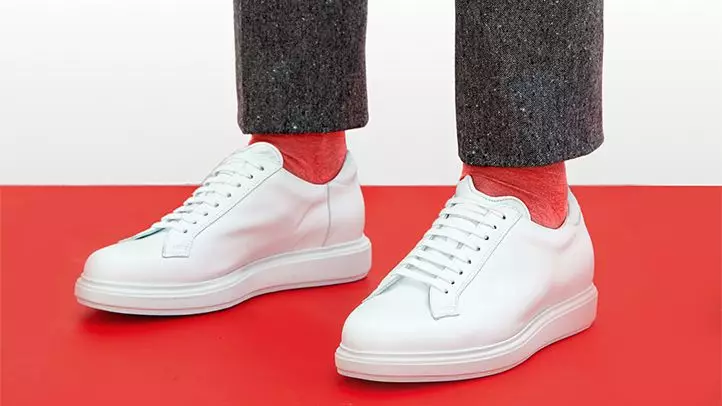 wäiss Sneakers rout Socken op roude Buedem schwaarz Hosen