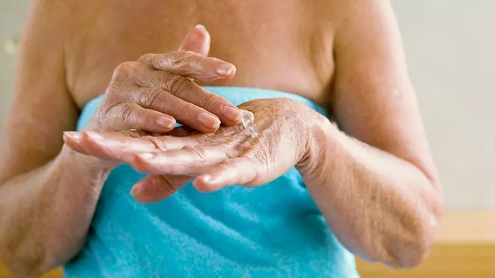 femme appliquant une lotion sur les mains