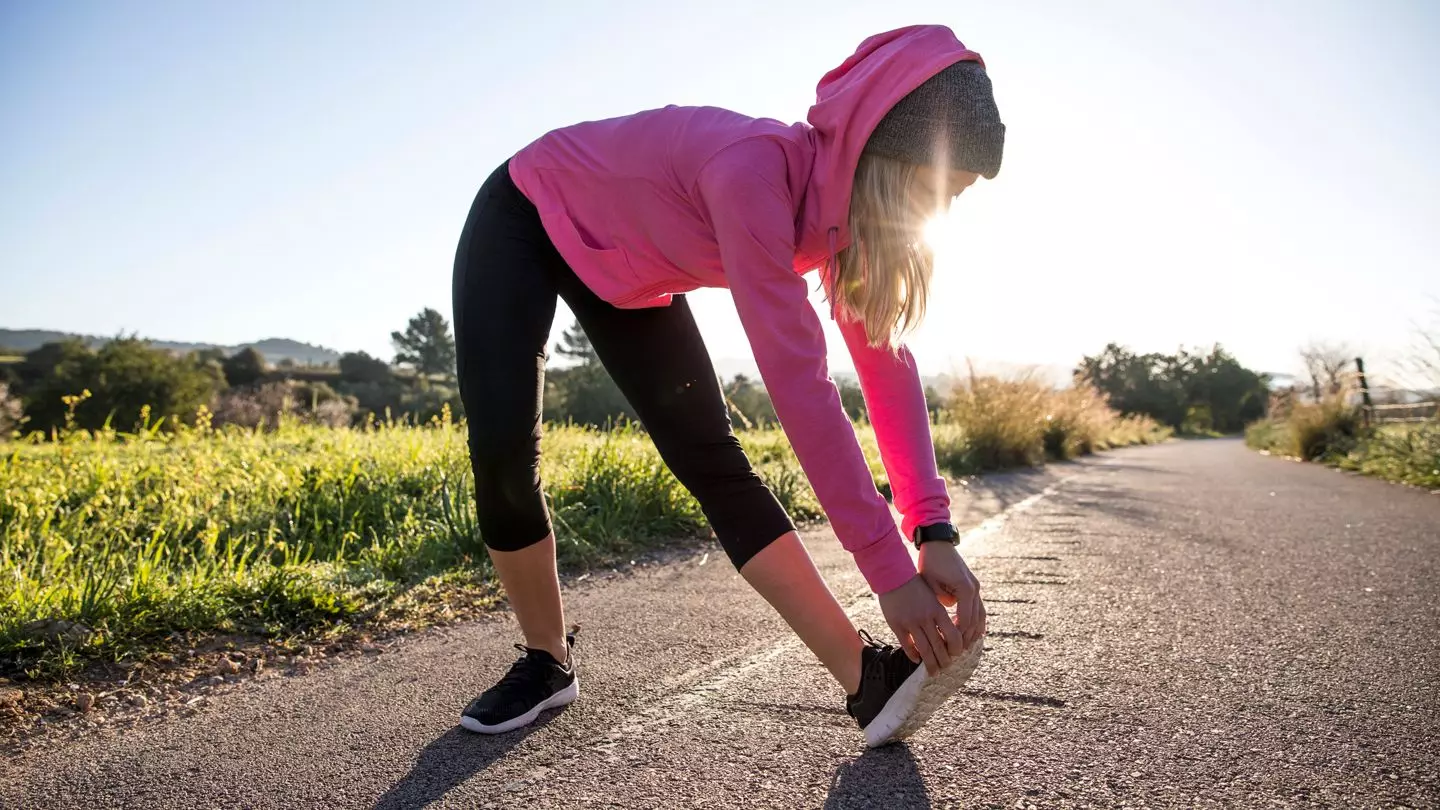 ung kvinne stretching øvelse landlig vei