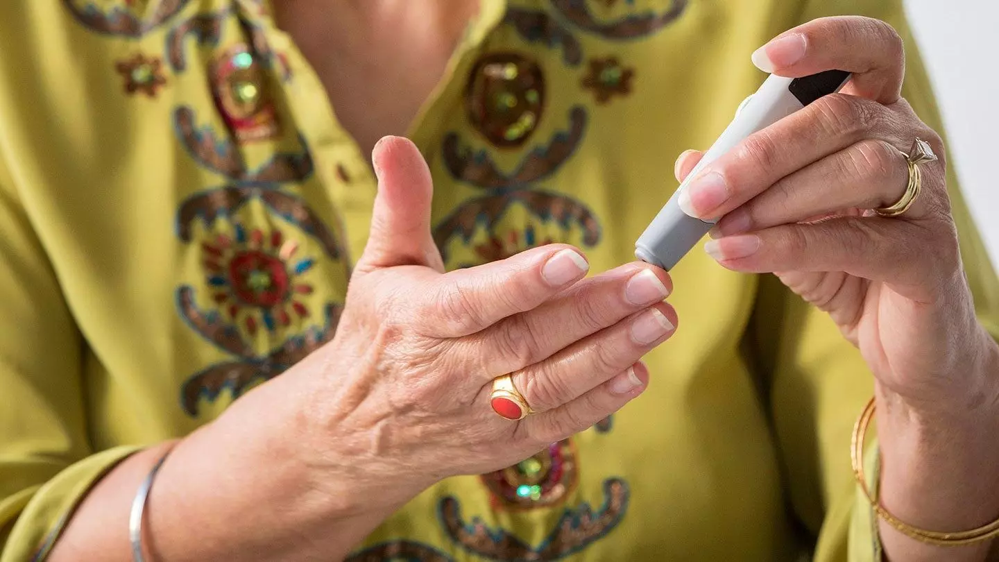 een vrouw met diabetes die in haar vinger prikt en haar bloedsuikerspiegel controleert