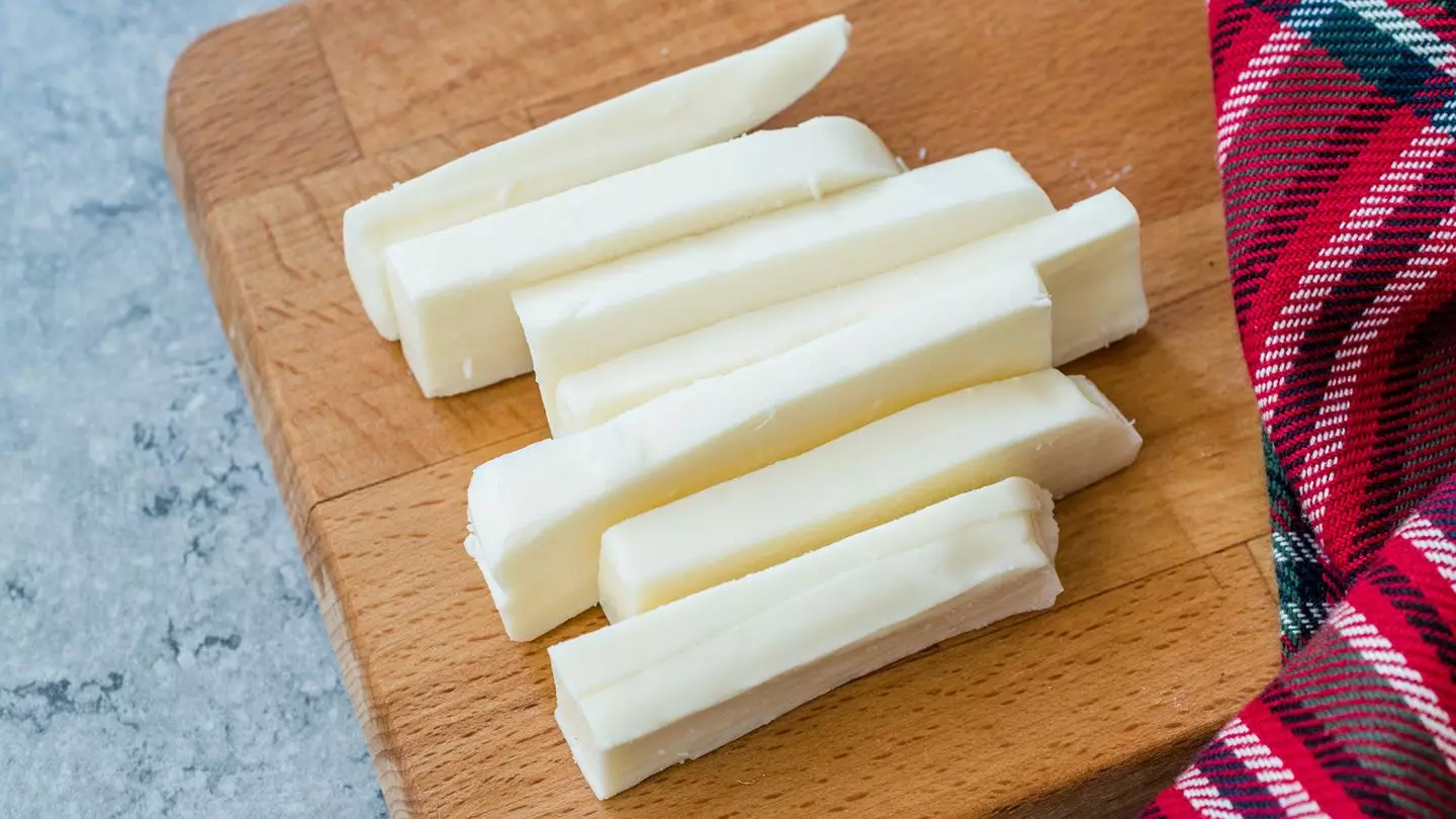 formaggio a fette di stringa sul tagliere di legno