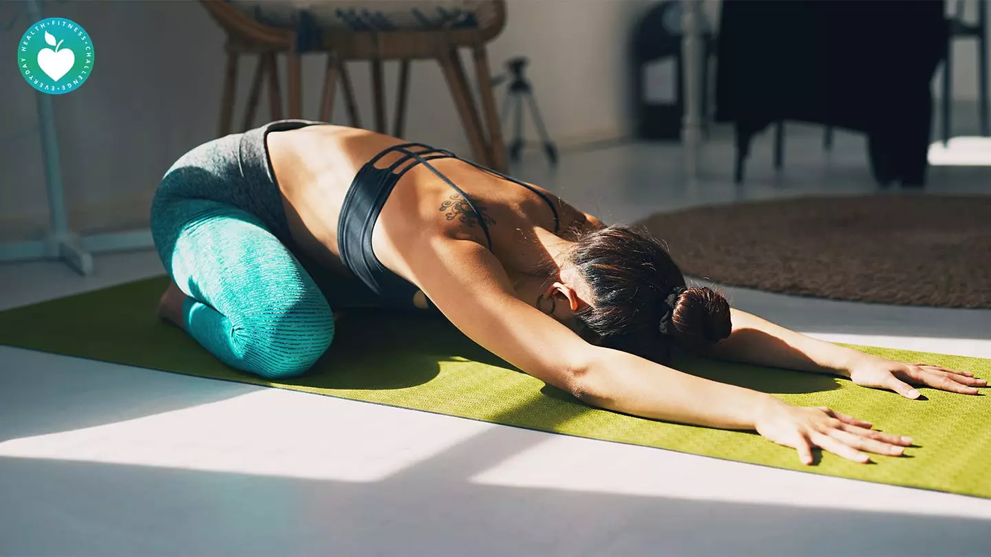 mukadzi ari kuita yoga pa green mat pose yemwana