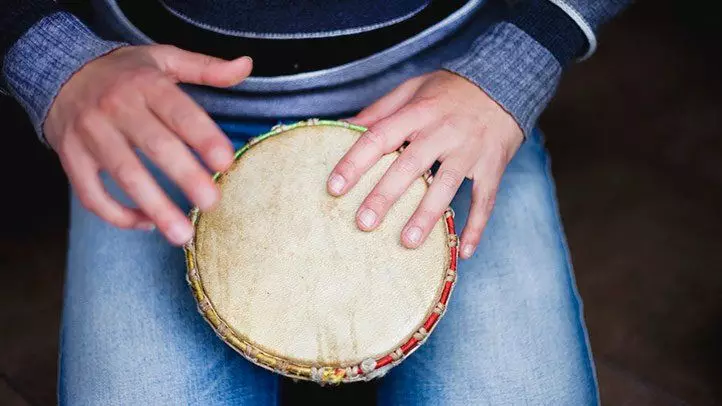 une personne jouant du bongo comme forme de musicothérapie